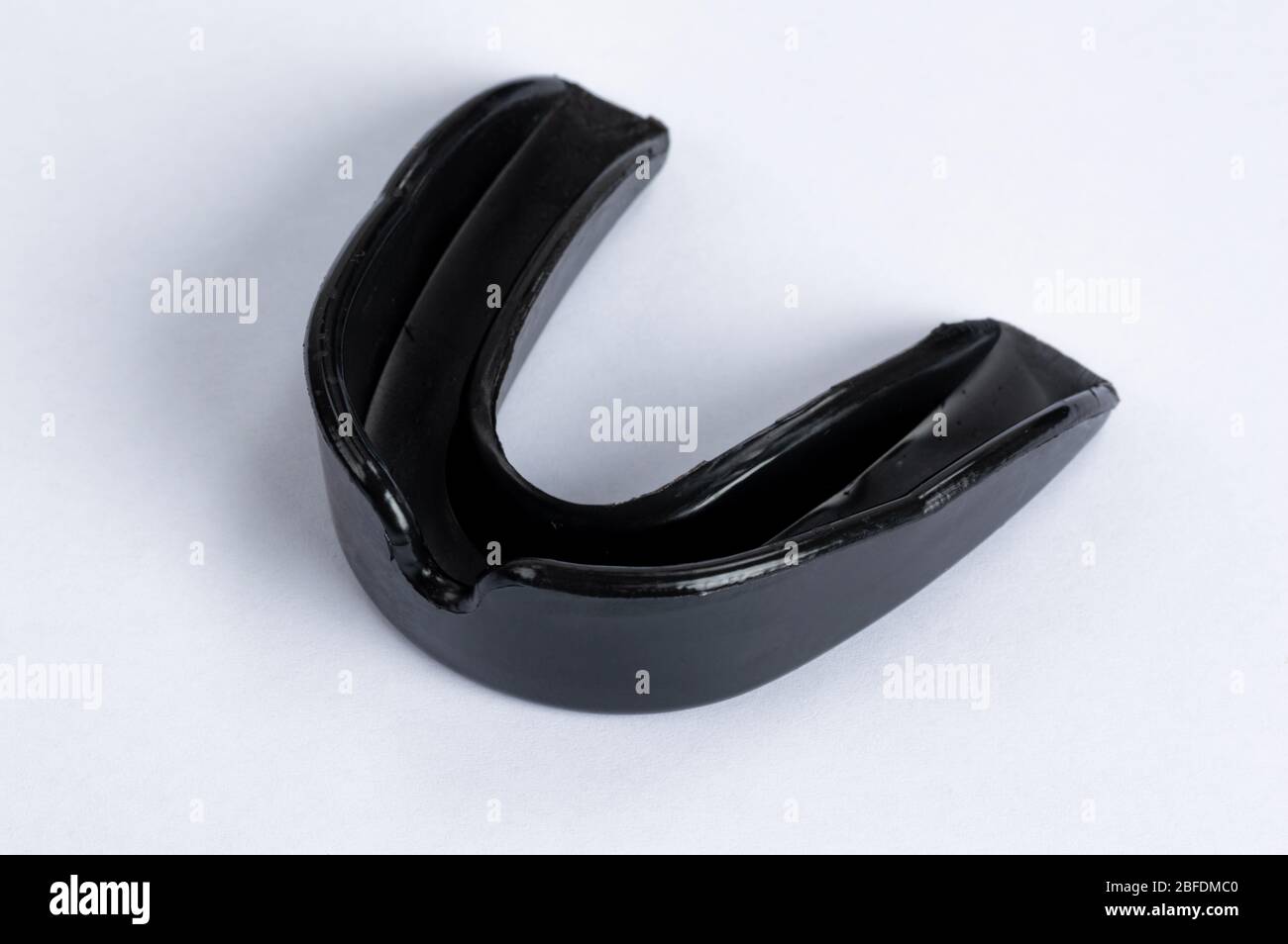 A close up of one black gumshield against a white background Stock ...