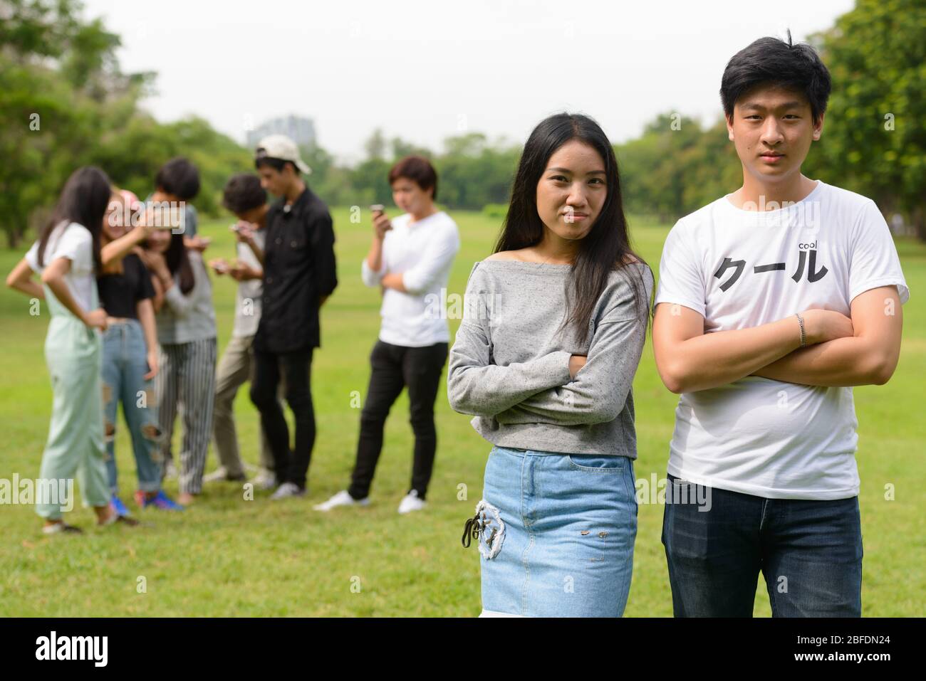 Young Asian couple together with friends at the park Stock Photo - Alamy