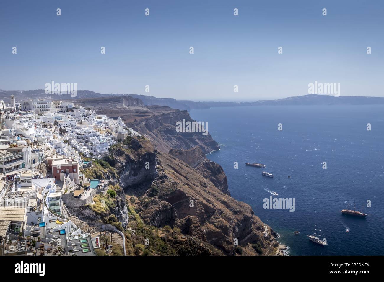 Thira city on Santorini island on a clear sunny day. Cliff overlooking ...