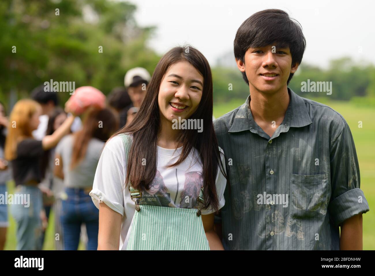 Happy young Asian couple together with friends at the park Stock Photo ...