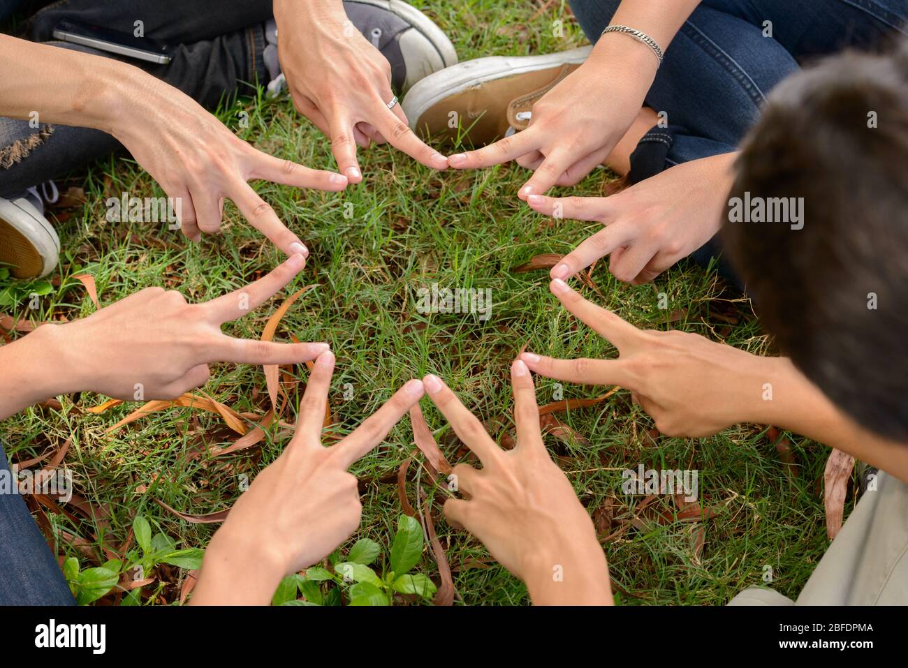 Group of friends forming fingers as star together as teamwork concept ...