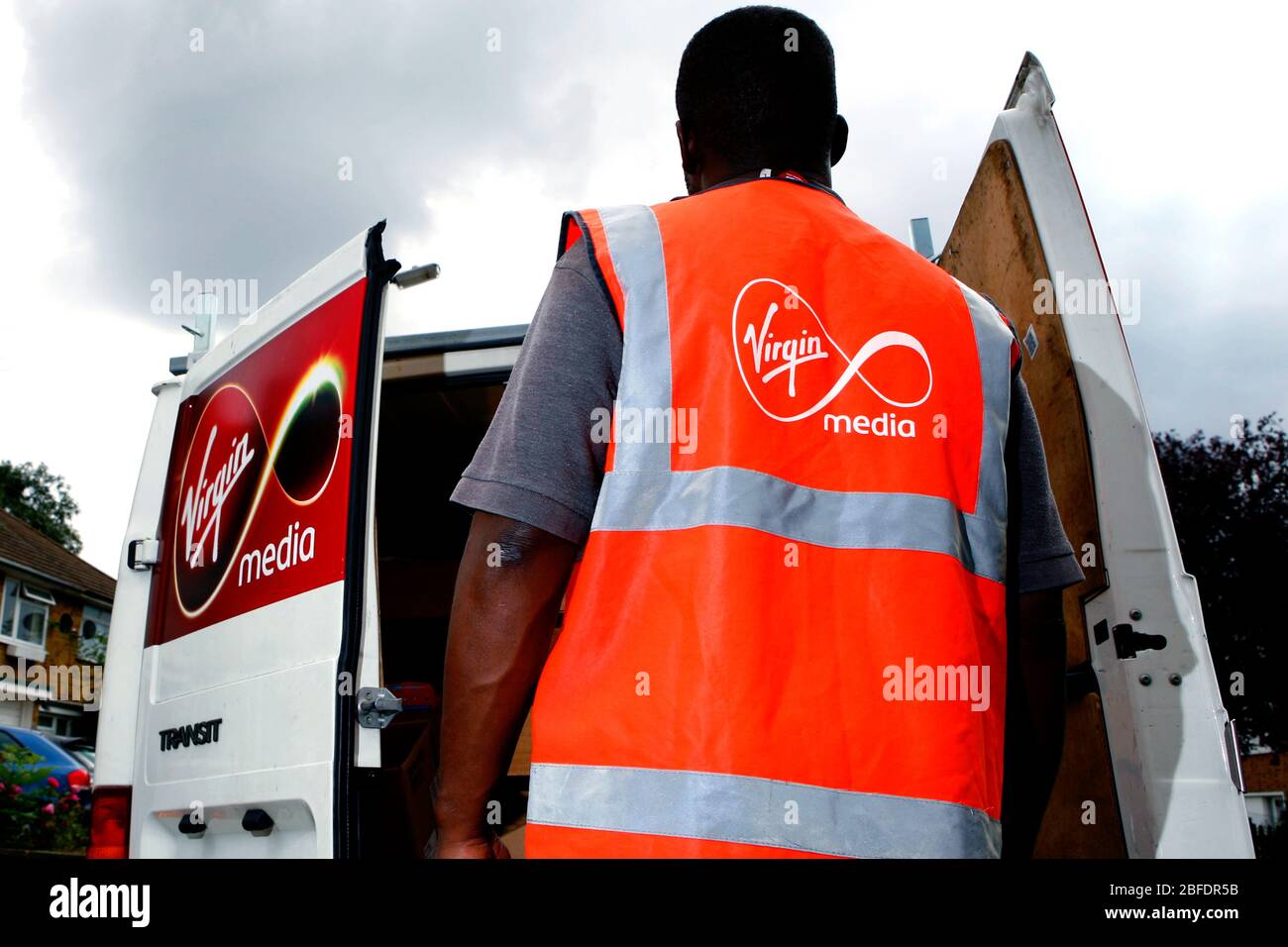 A Virgin Media employee delivering a digital tv reciever Stock Photo ...
