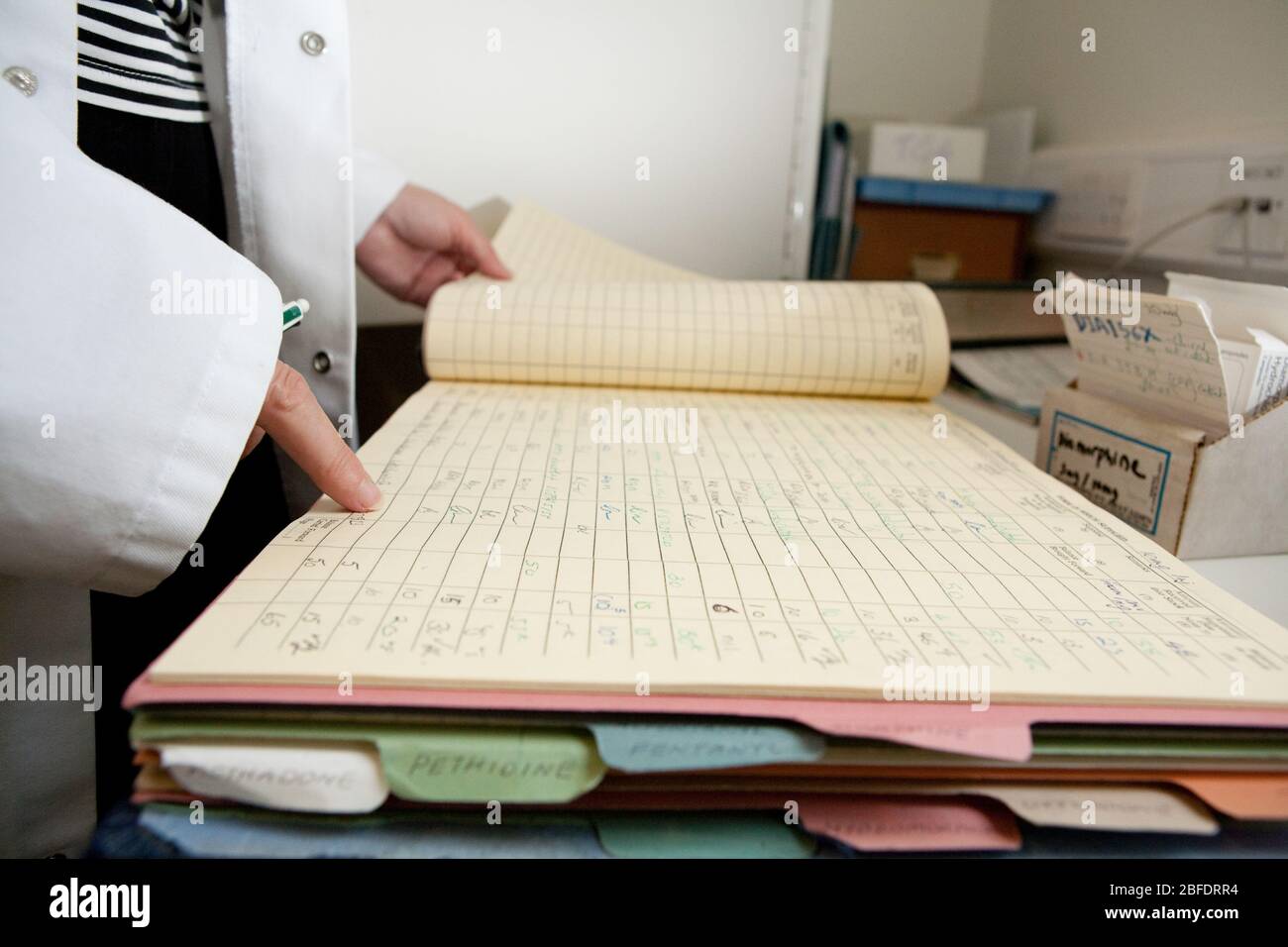 A pharmacist reading a log book of medication Stock Photo - Alamy