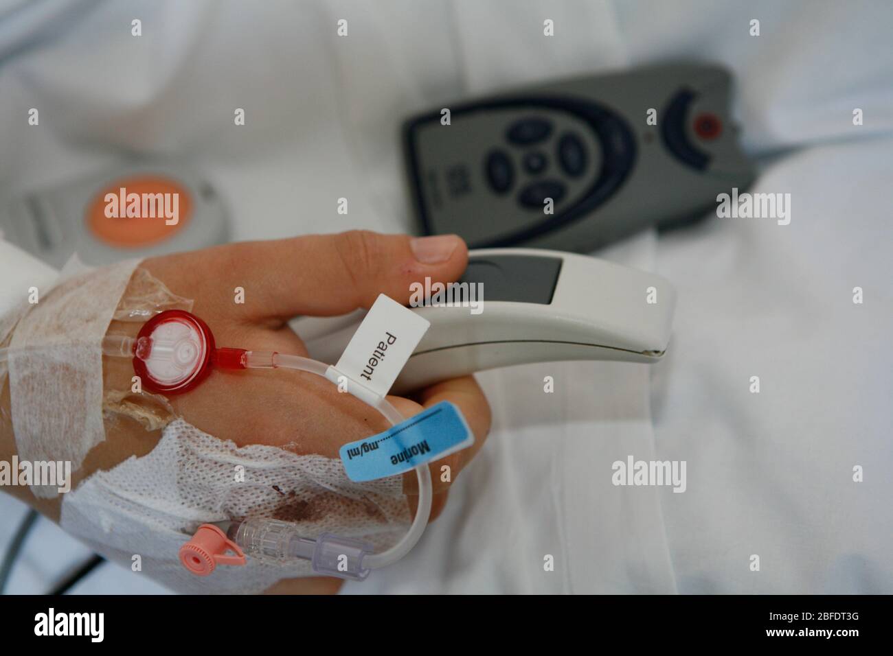A bed-ridden patient presses the emergency alarm attached to their ...