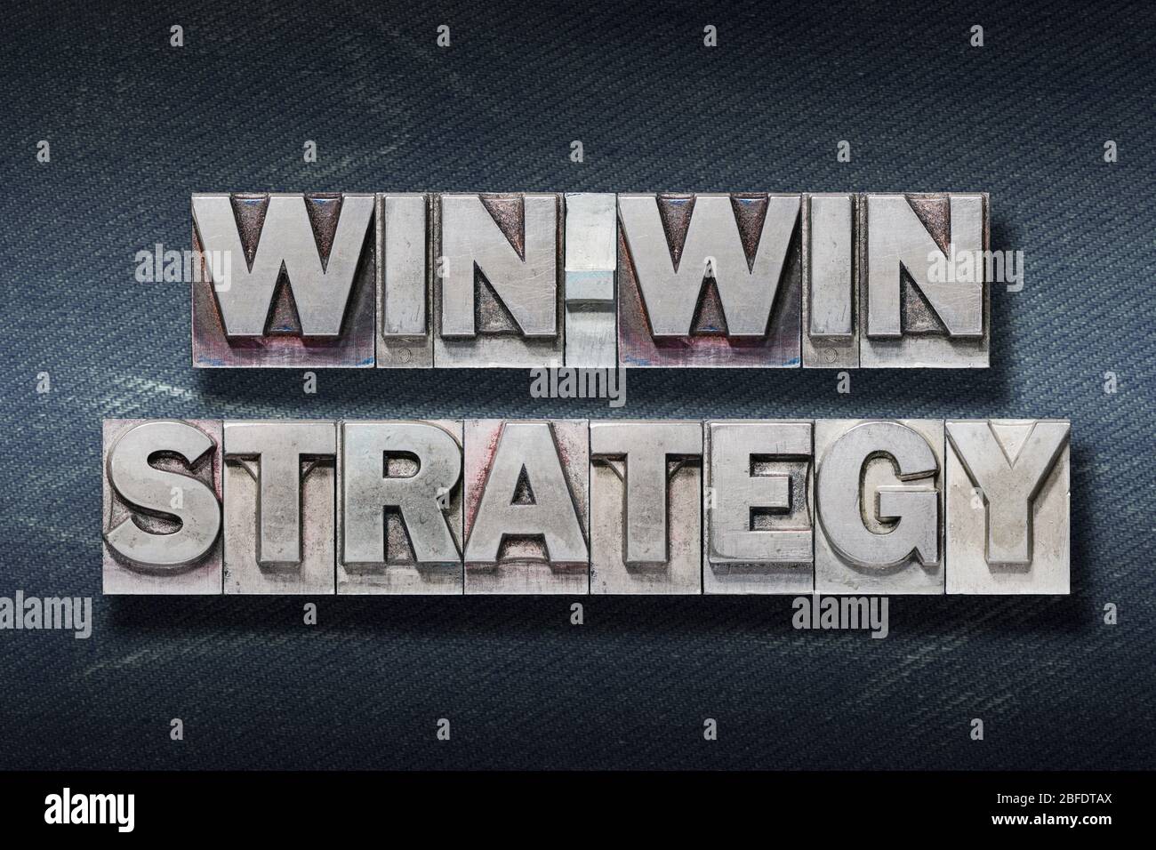 win-win strategy phrase made from metallic letterpress on dark jeans ...