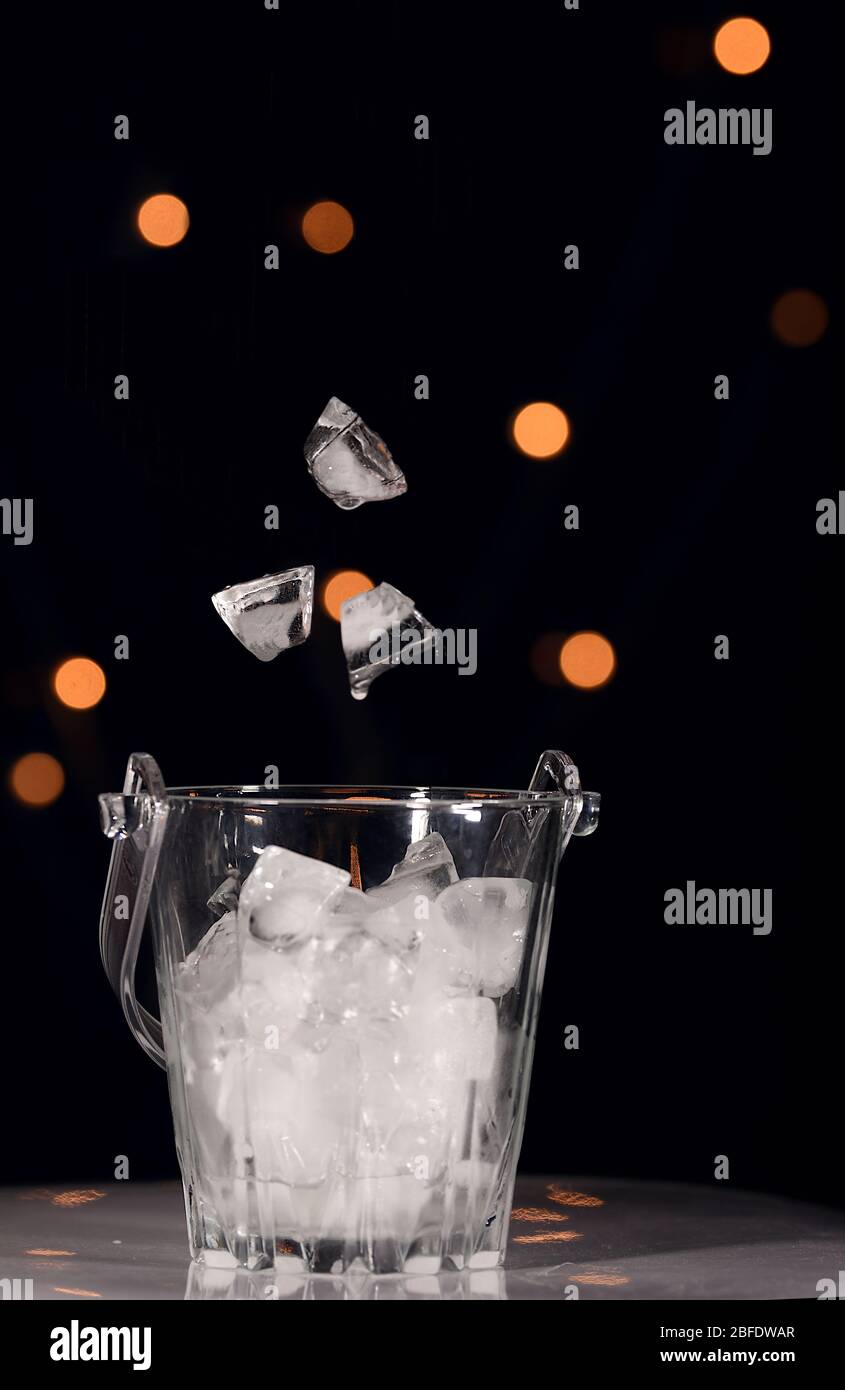 Dropping ice cubes inside ice bucket and photographed against beautiful ...