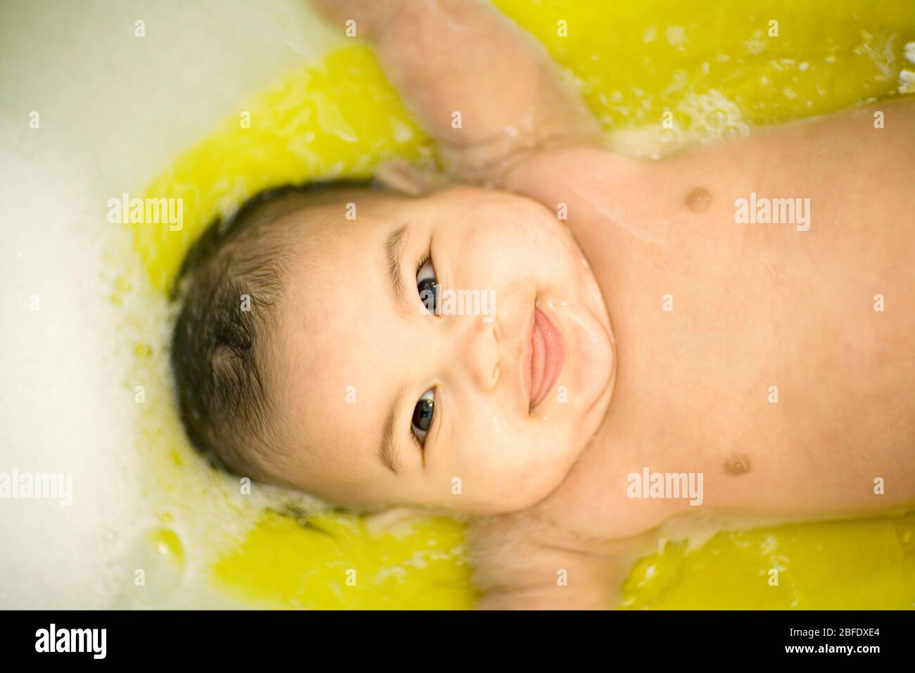 A baby being washed in a bath Stock Photo - Alamy