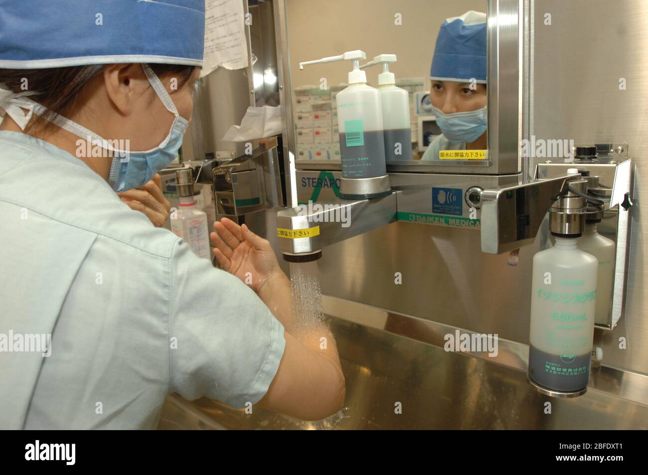 Nurse scrubbing up prior to consulting with a patient, Japanese Red ...