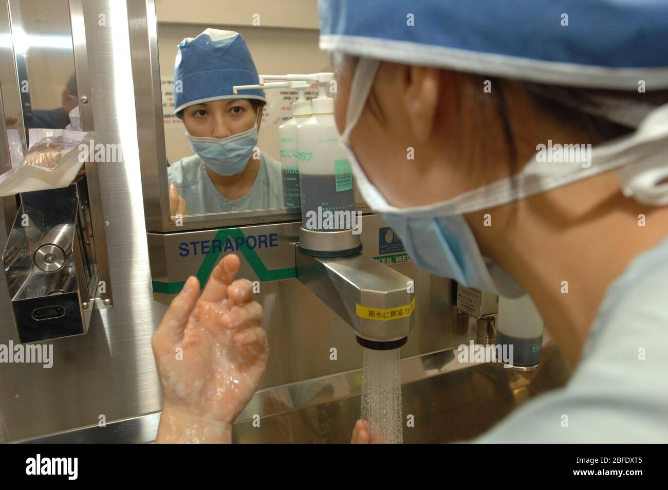Nurse scrubbing up prior to consulting with a patient, Japanese Red ...