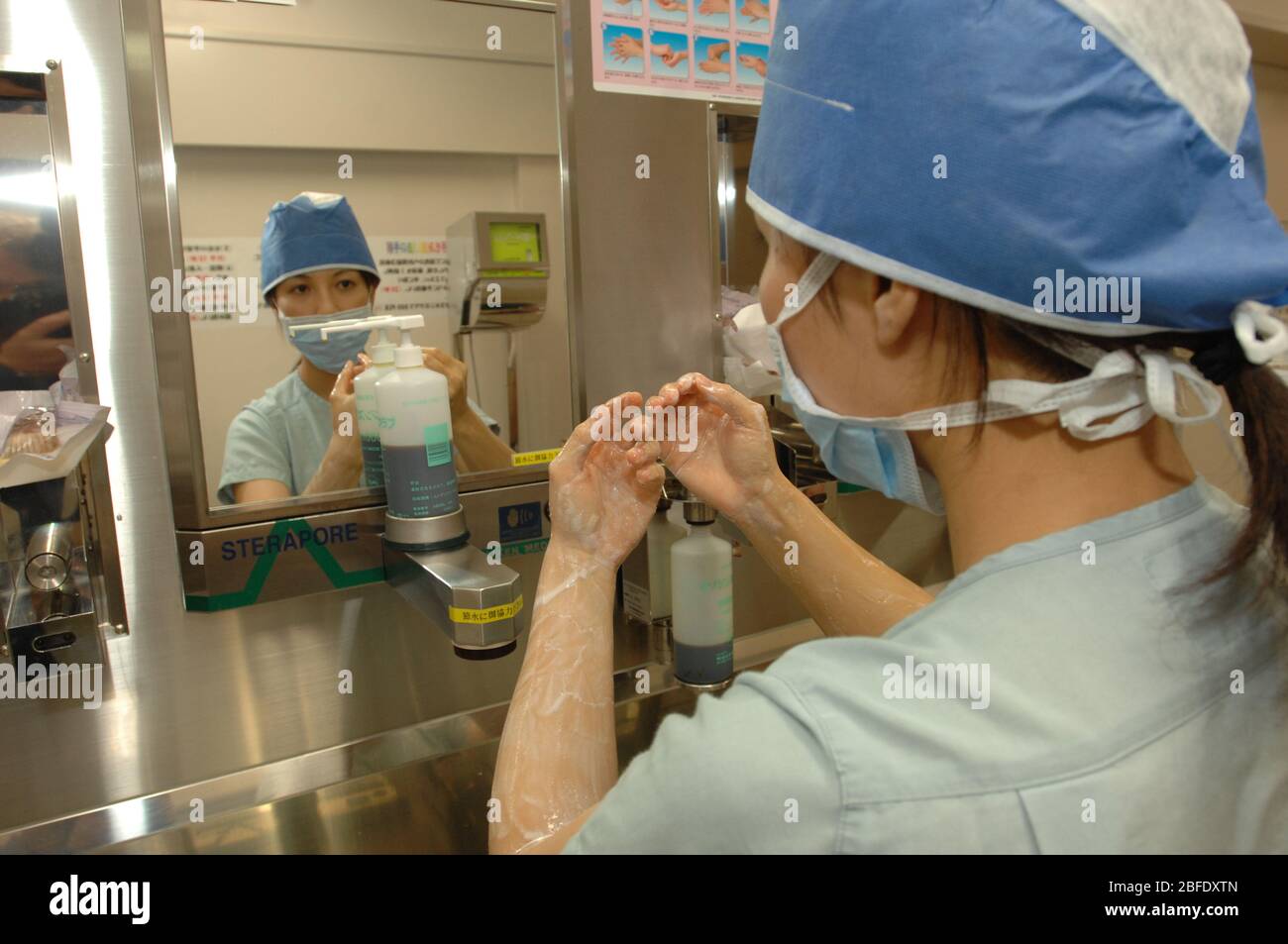 Nurse scrubbing up prior to consulting with a patient, Japanese Red ...