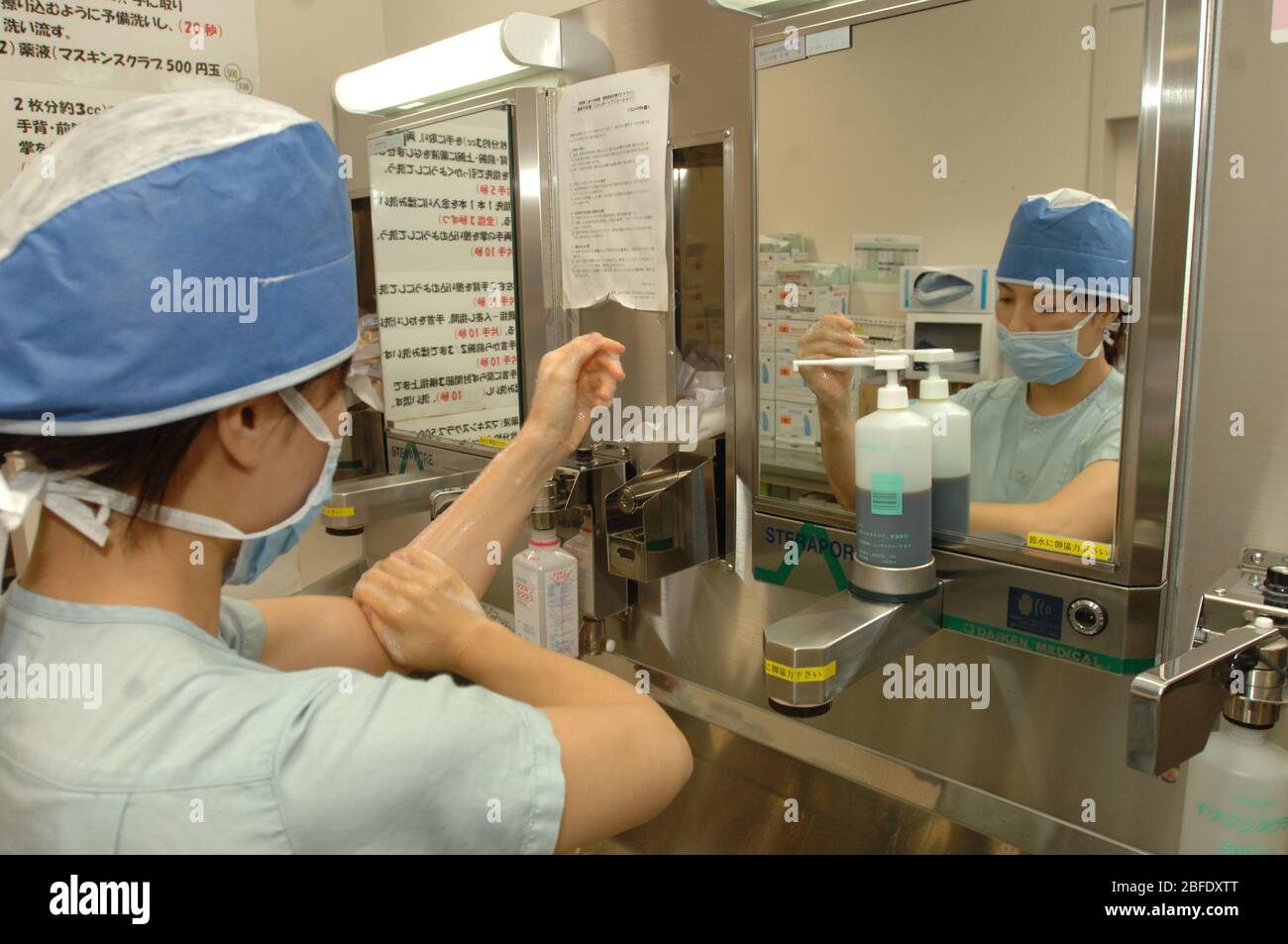 Nurse scrubbing up prior to consulting with a patient, Japanese Red ...