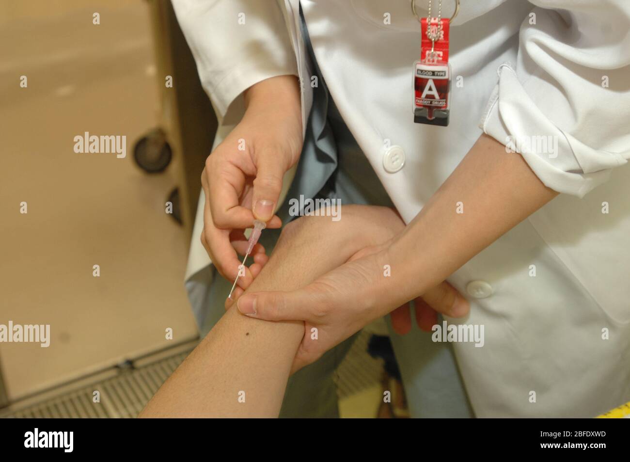 Doctors injecting a patient with medication Stock Photo - Alamy