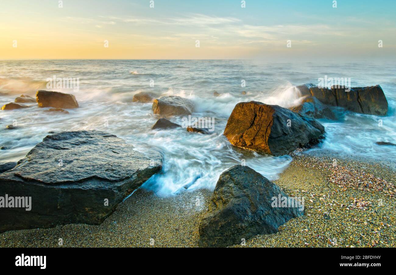 Dawn on the rock-strewn shores of Meig's Point on Long Island Sound ...