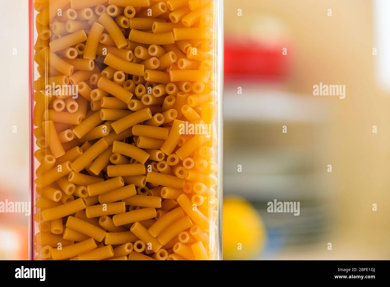 raw italian macaroni pasta inside clear storage container Stock Photo ...