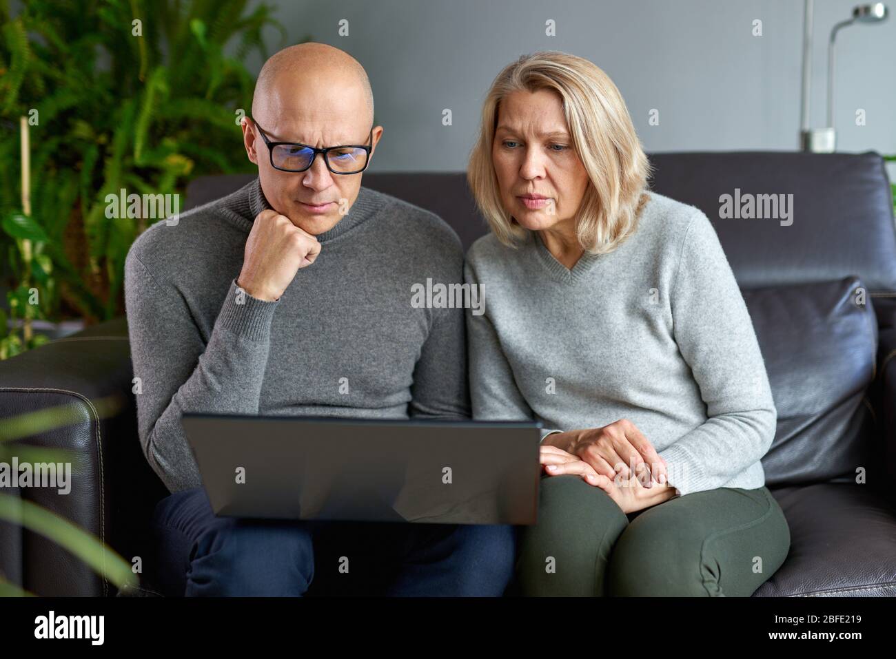 Middle-aged mom rest in living room with adult child use computer ...