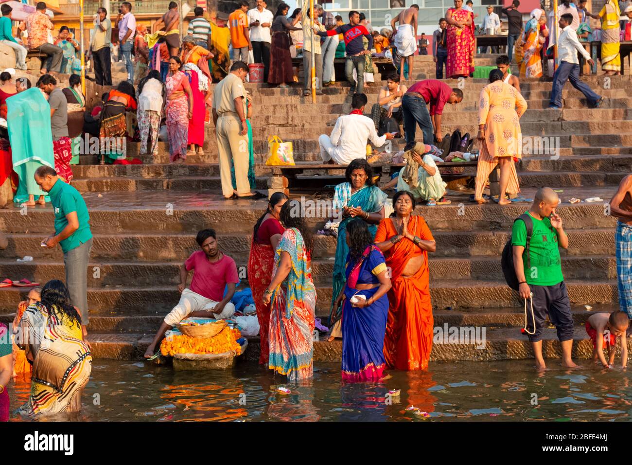 Pilgrims bathing in Holy Ganges river at sunrise in Varanasi, India ...