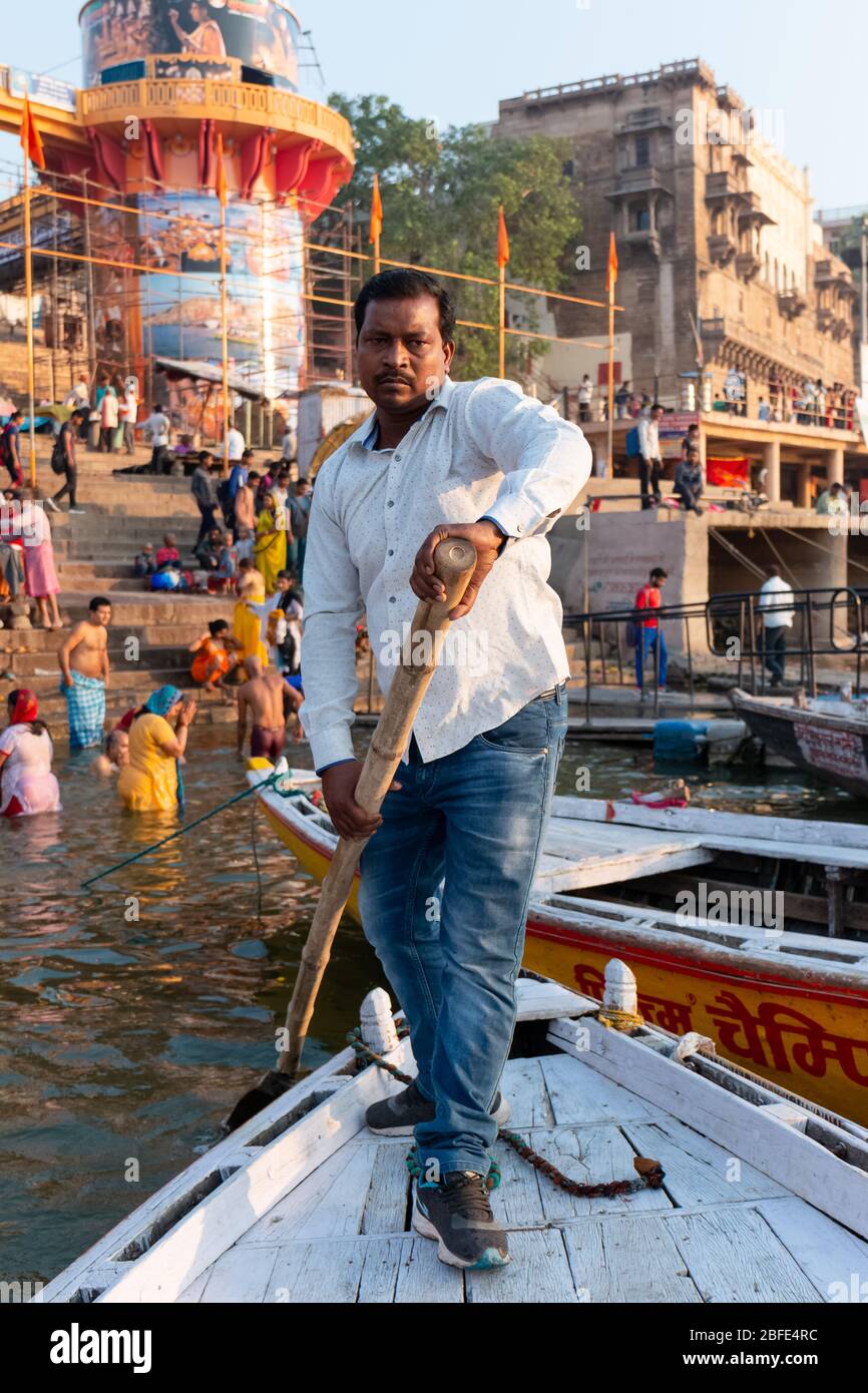 VARANASI, UTTAR PRADESH / INDIA - APRIL 2019 : Boatman carrying his ...