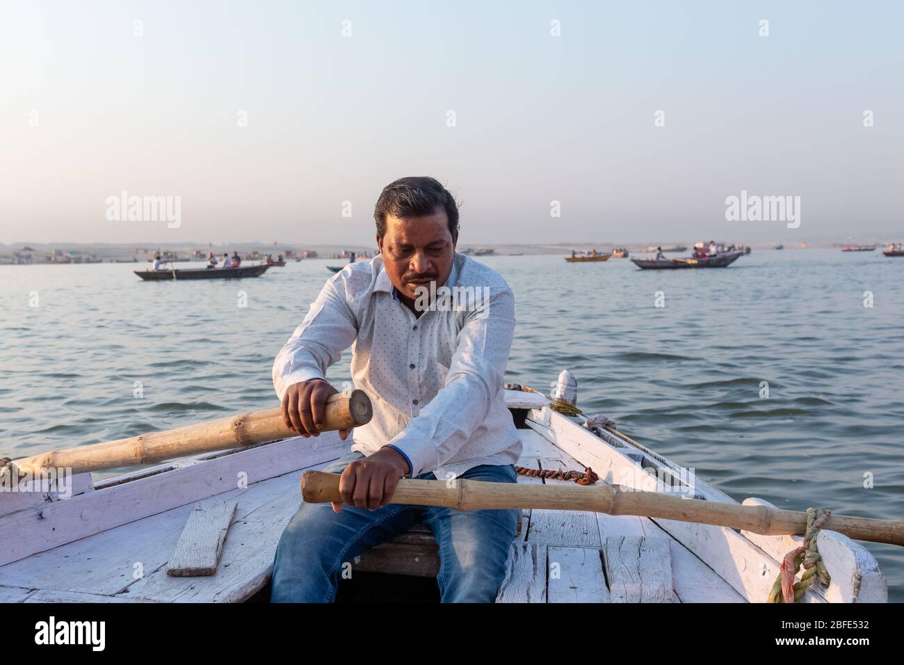 VARANASI, UTTAR PRADESH / INDIA - APRIL 2019 : Boatman carrying his ...