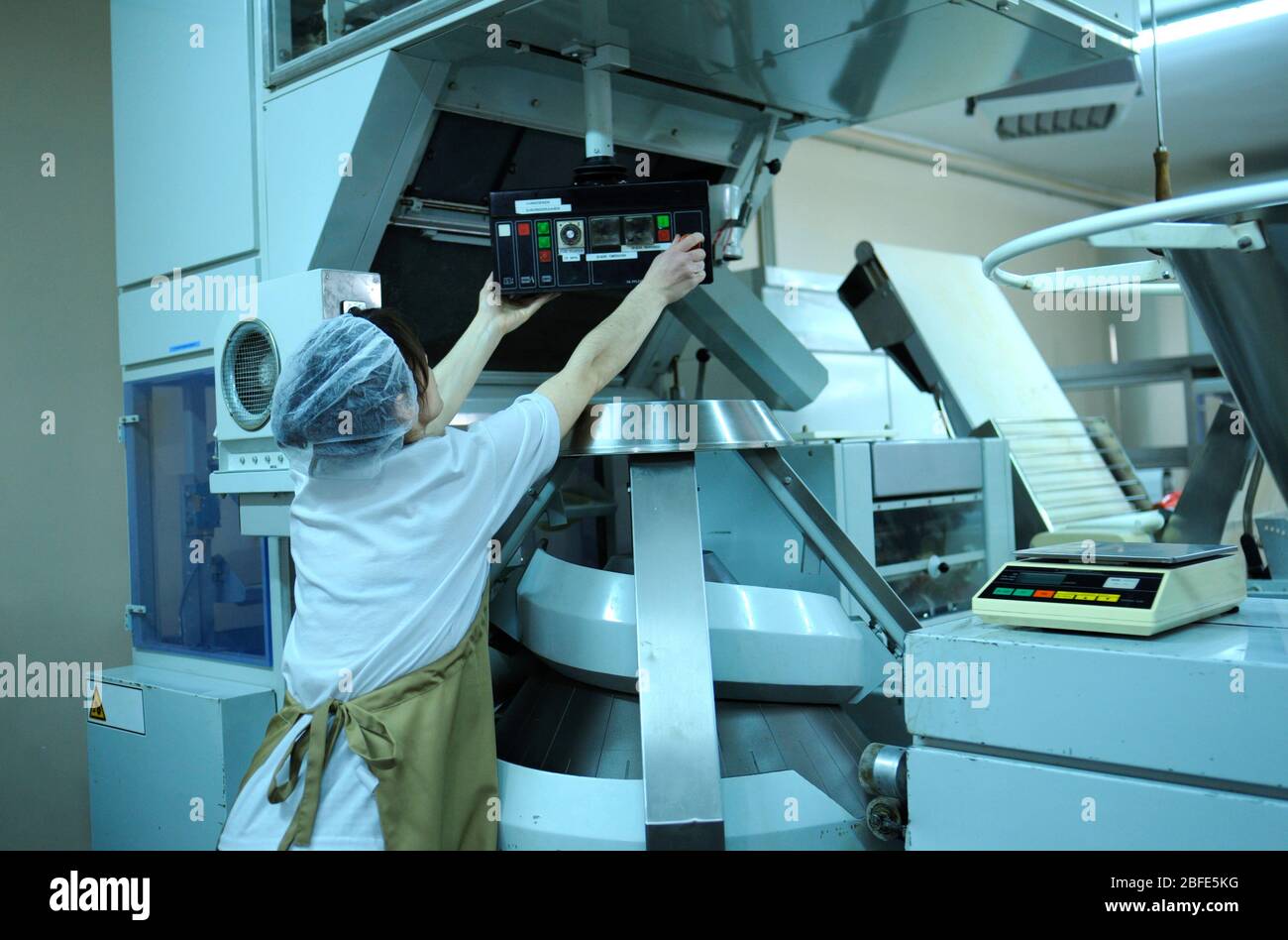 At the bakery: female baker regulating level of power on a control ...