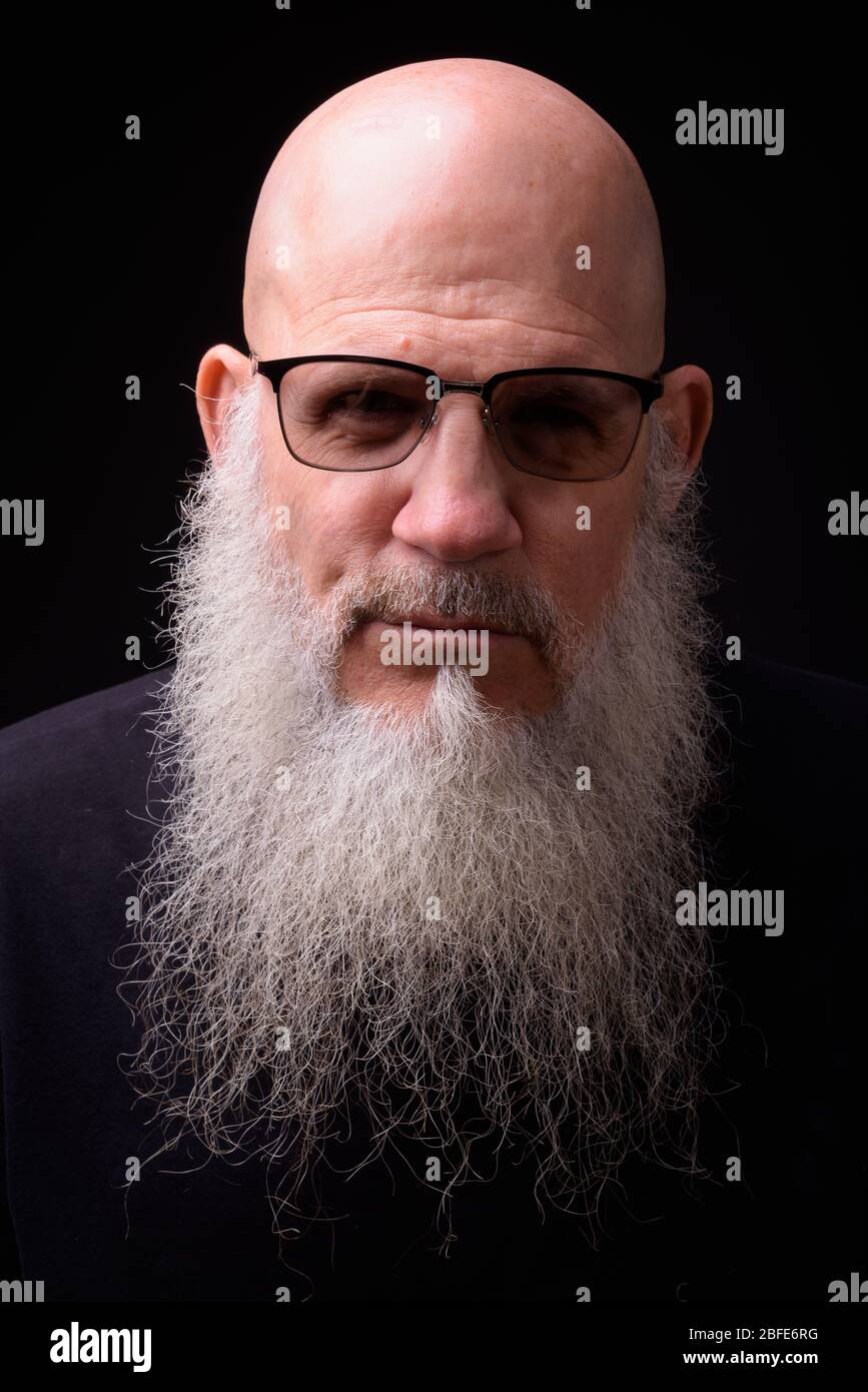 Mature bald bearded man against black background Stock Photo - Alamy
