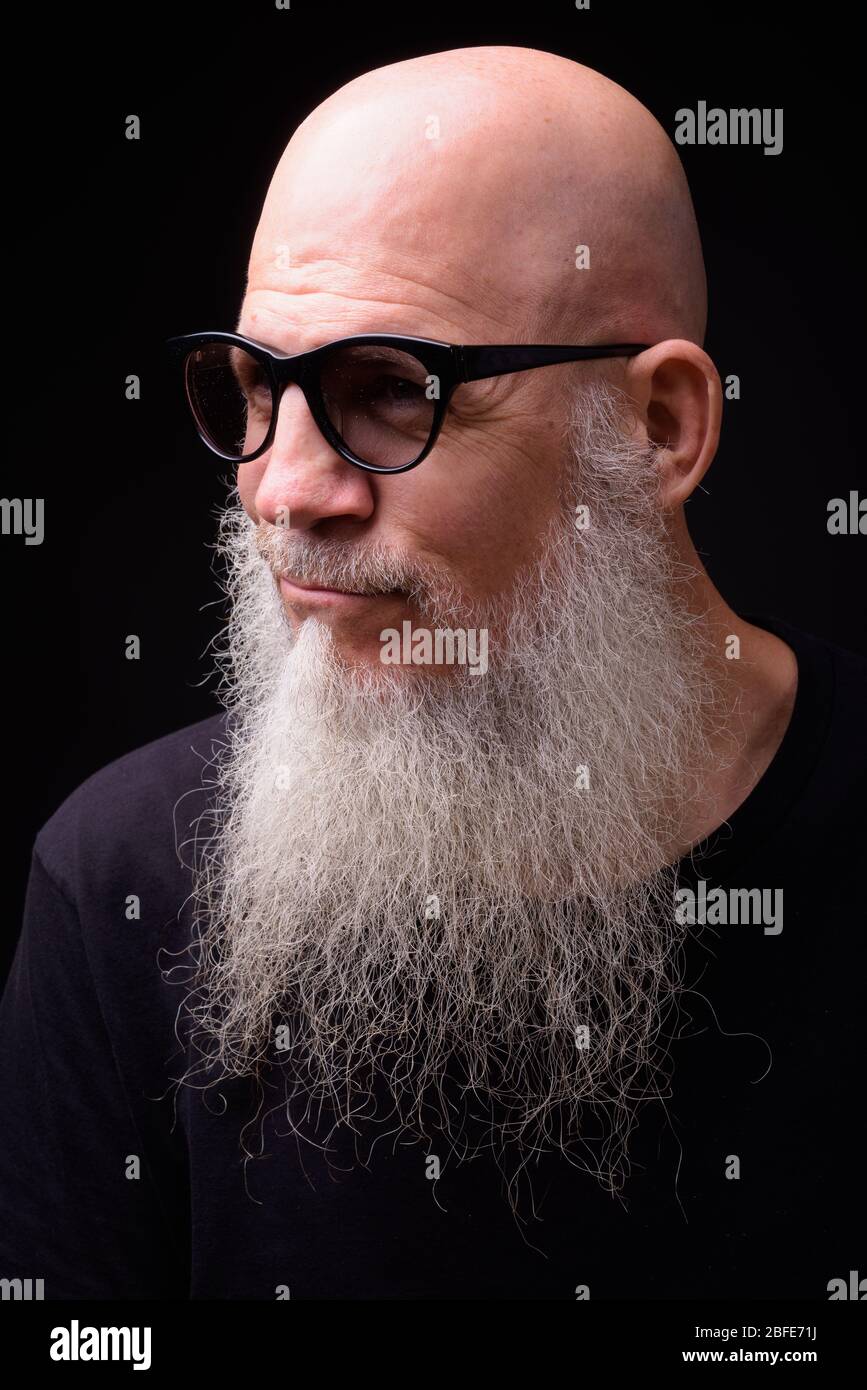 Mature bald bearded man against black background Stock Photo - Alamy