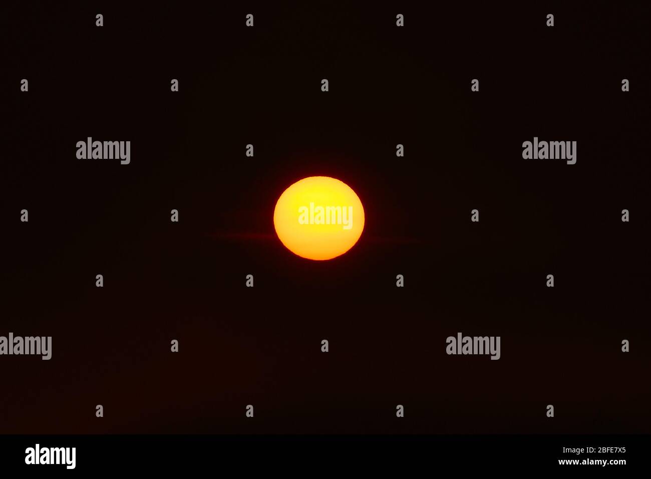 Orange sun in the dark sunset sky Stock Photo - Alamy