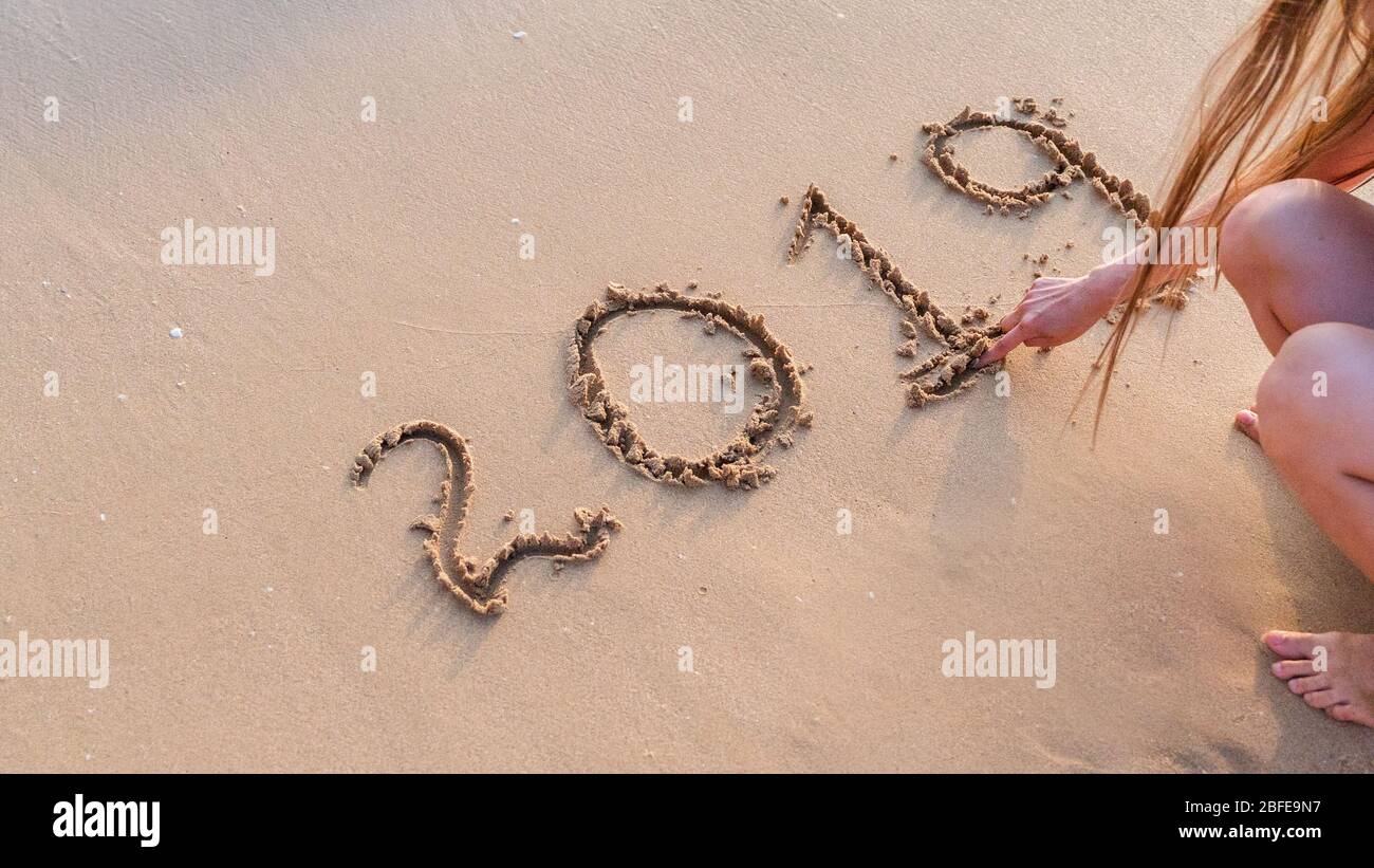 Woman writting 2020 on sand hi-res stock photography and images - Alamy