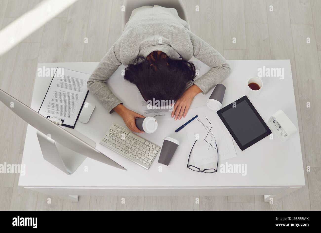Tired business woman lies asleep at the desk workplace in the office ...