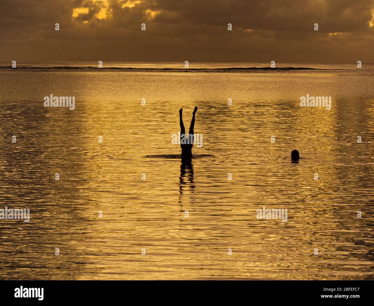 Gym movement in the ocean water at sunset in Reunion Island, a way to ...