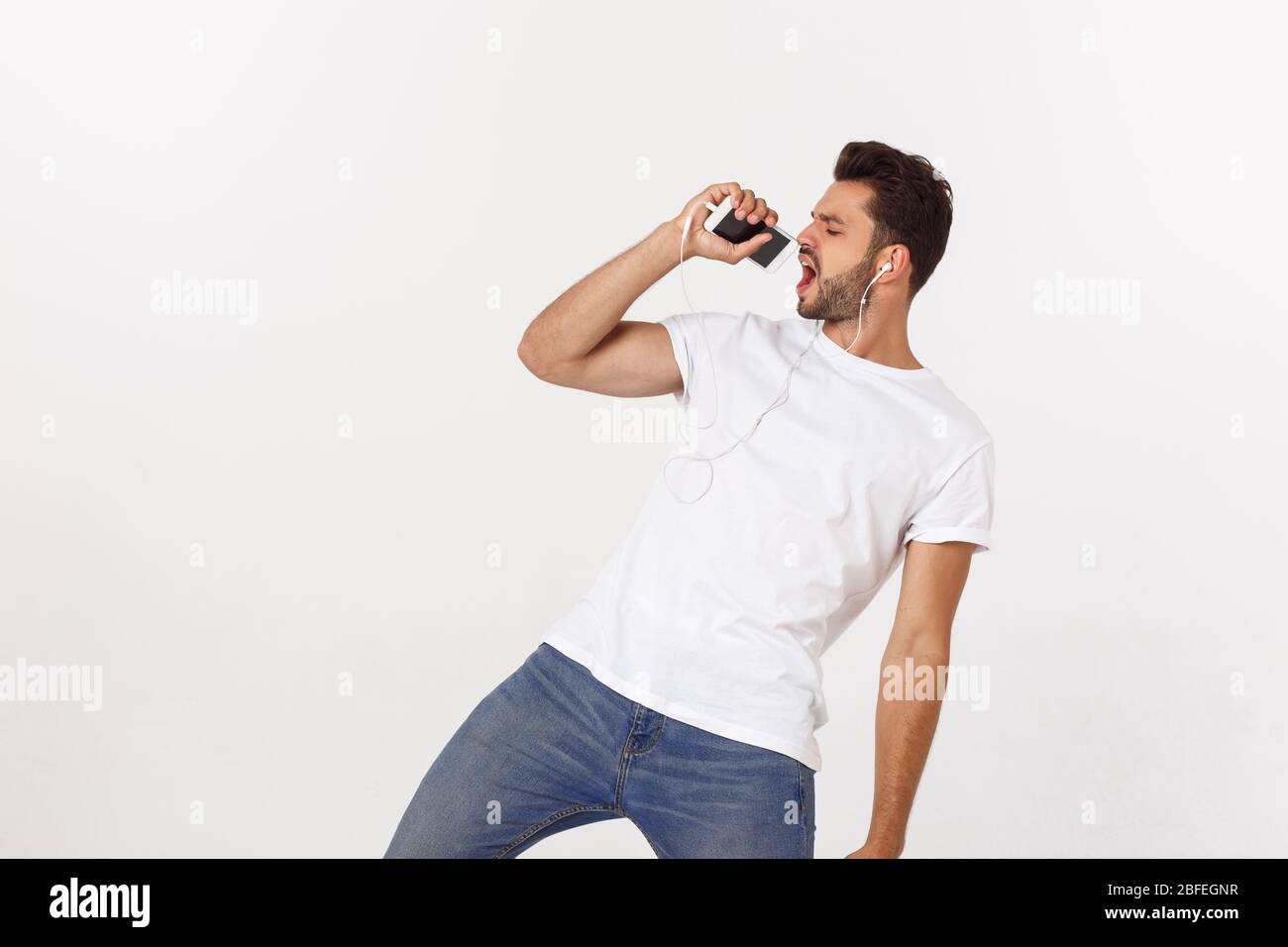 Casual handsome man dancing with mobile phone isolated on white ...