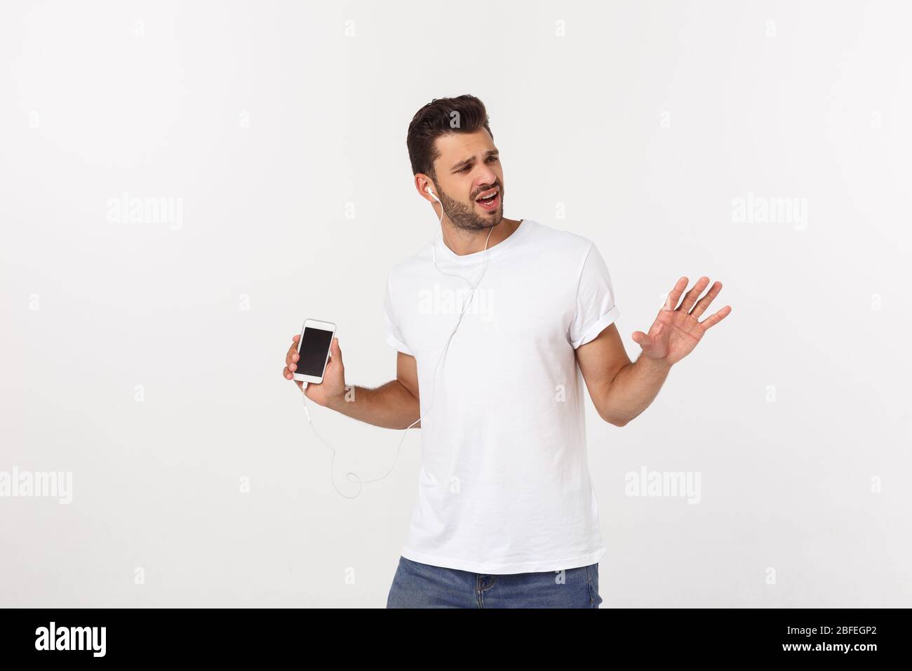 Casual handsome man dancing with mobile phone isolated on white ...