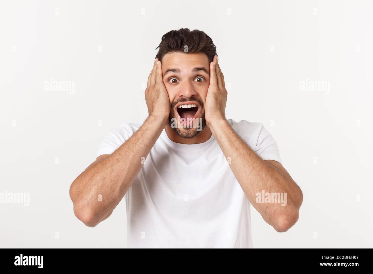 Portrait of young man with shocked facial expression, isolated over ...