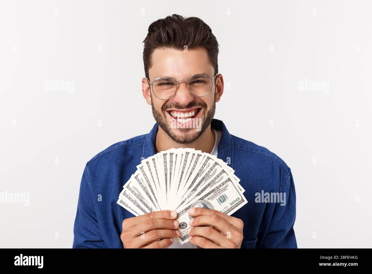 Attractive man is holding cash money in one hand, on isolated white ...