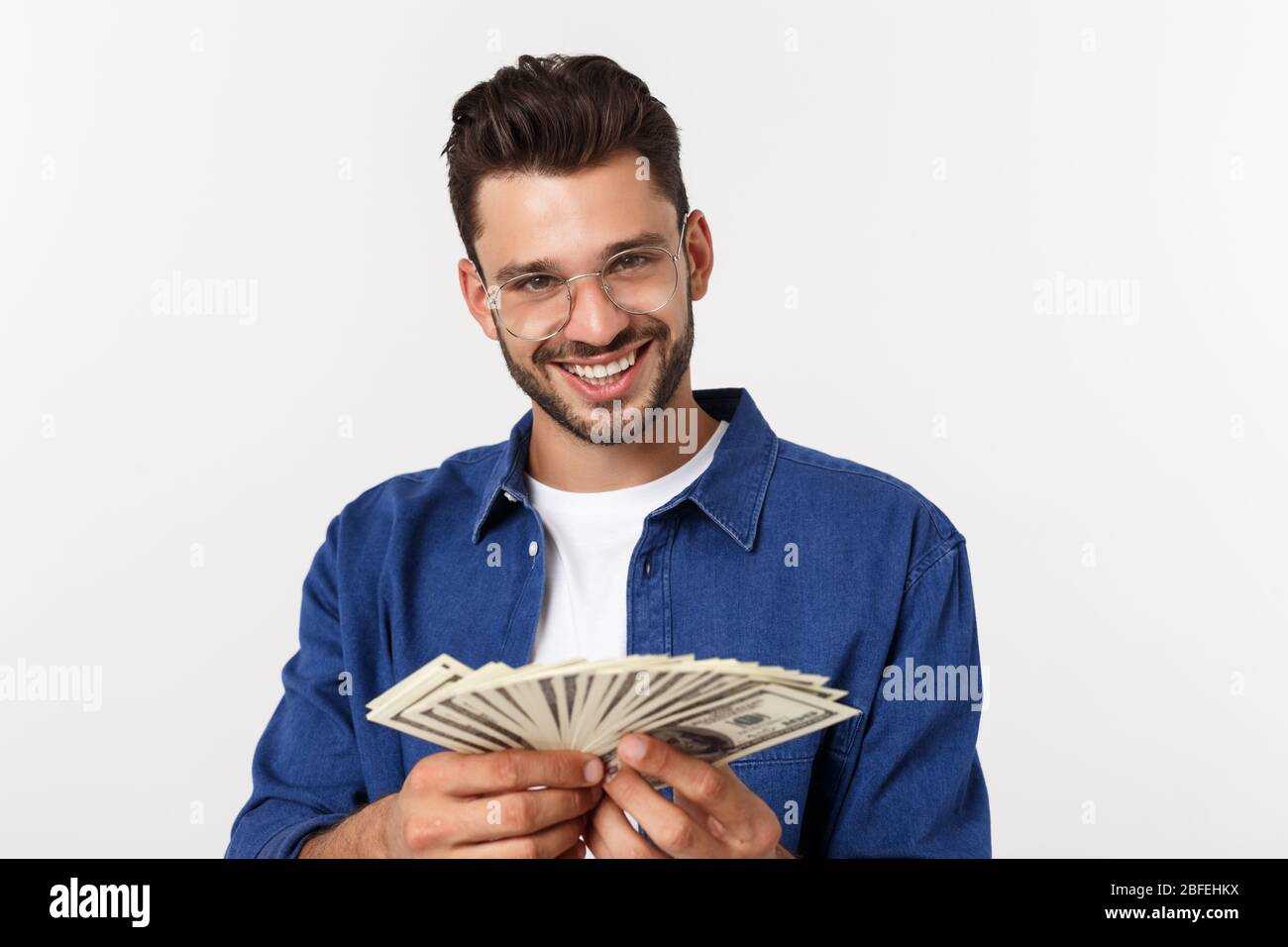 Attractive man is holding cash money in one hand, on isolated white ...