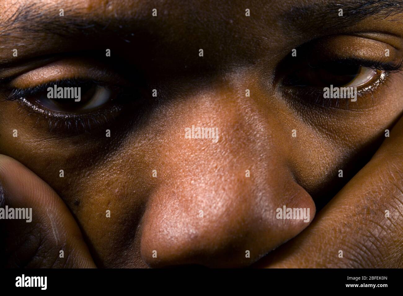 A young man holds his right hand to his face Stock Photo - Alamy