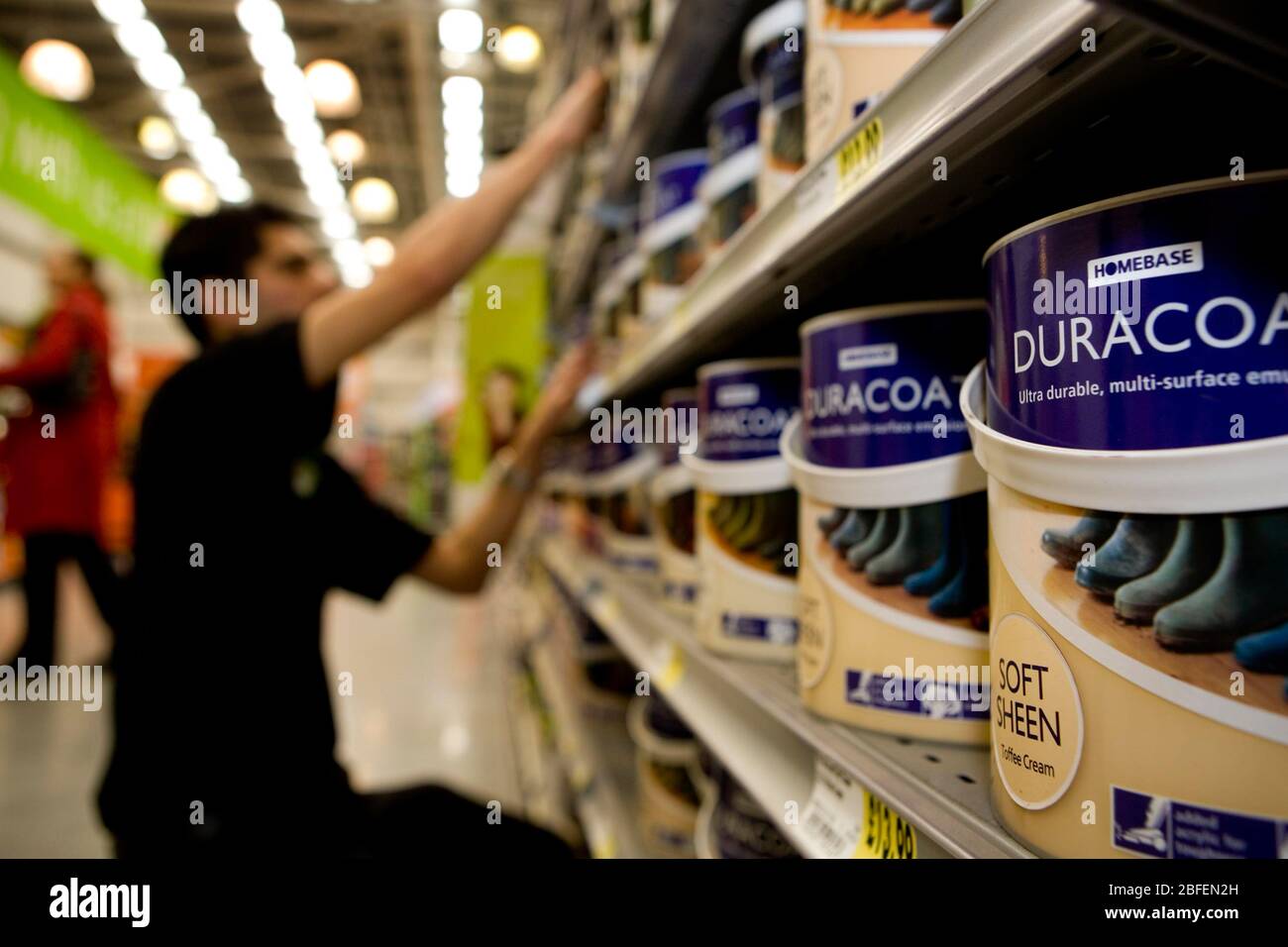 A Homebase employee re-stocking the selves of a paint isle Stock Photo ...