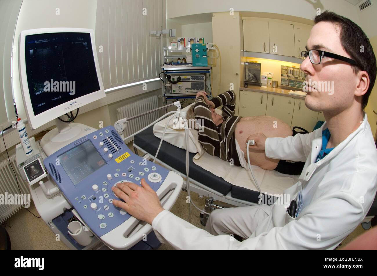 Doctor uses a doppler ultrasound scanner to examine a blood vessel in a ...