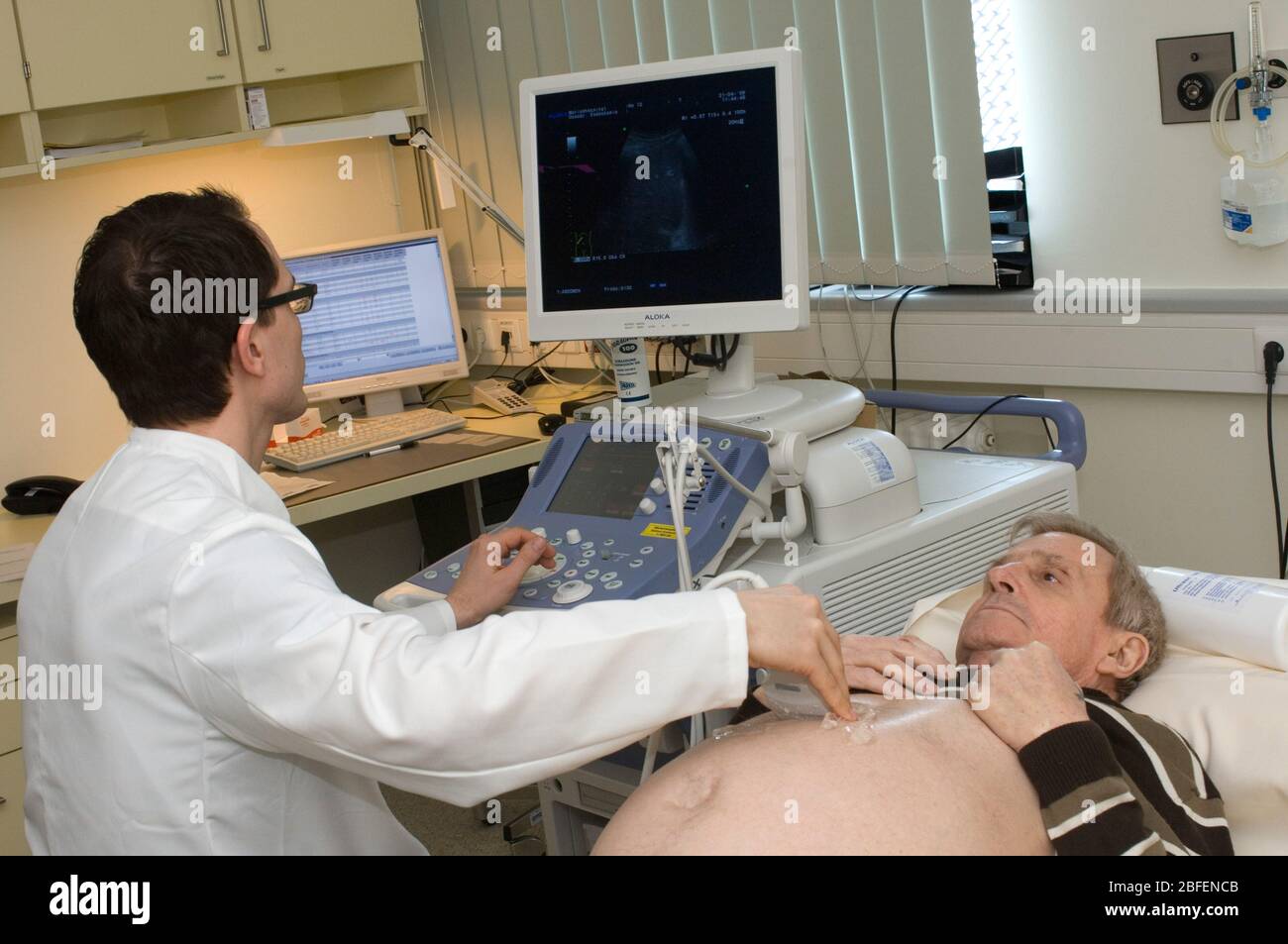 Doctors uses a doppler ultrasound scanner to examine a blood vessel in ...
