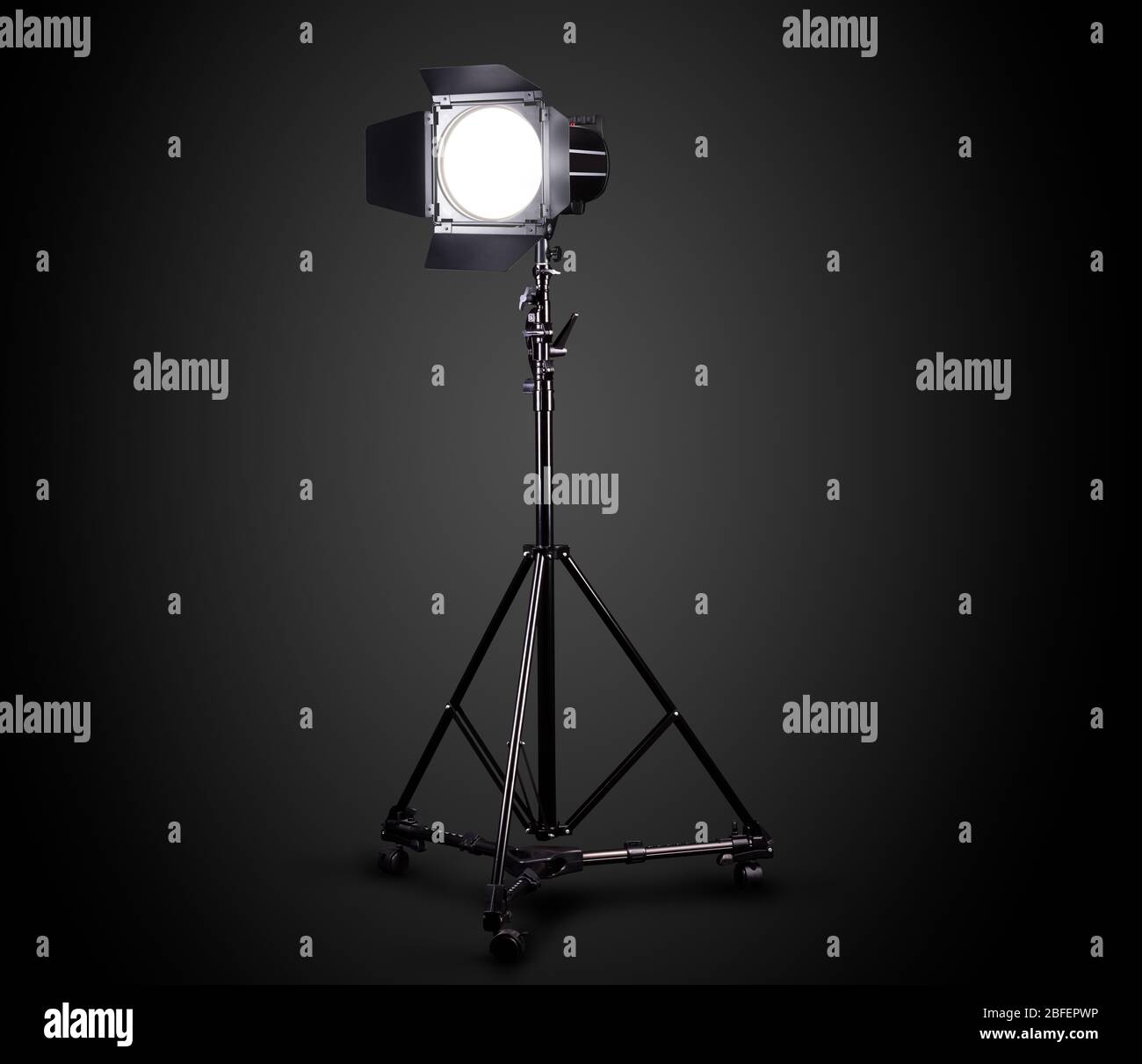 Photography studio flash on a lighting stand isolated on black ...