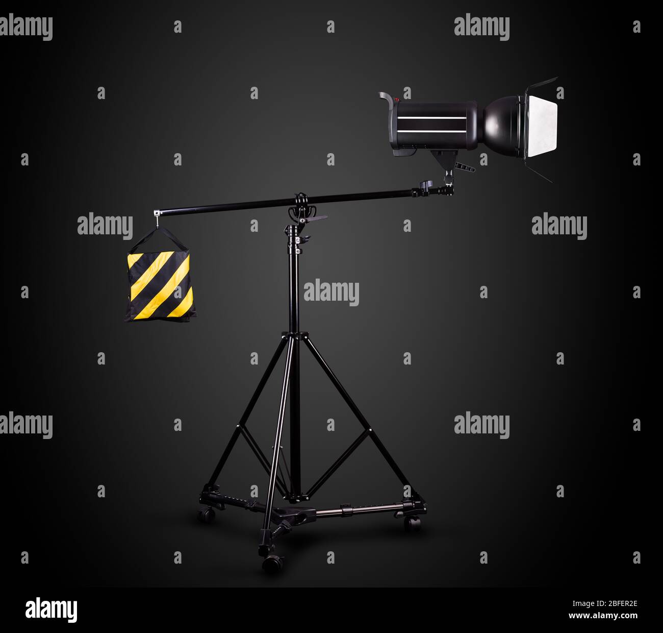 Photography studio flash on a lighting stand isolated on black ...