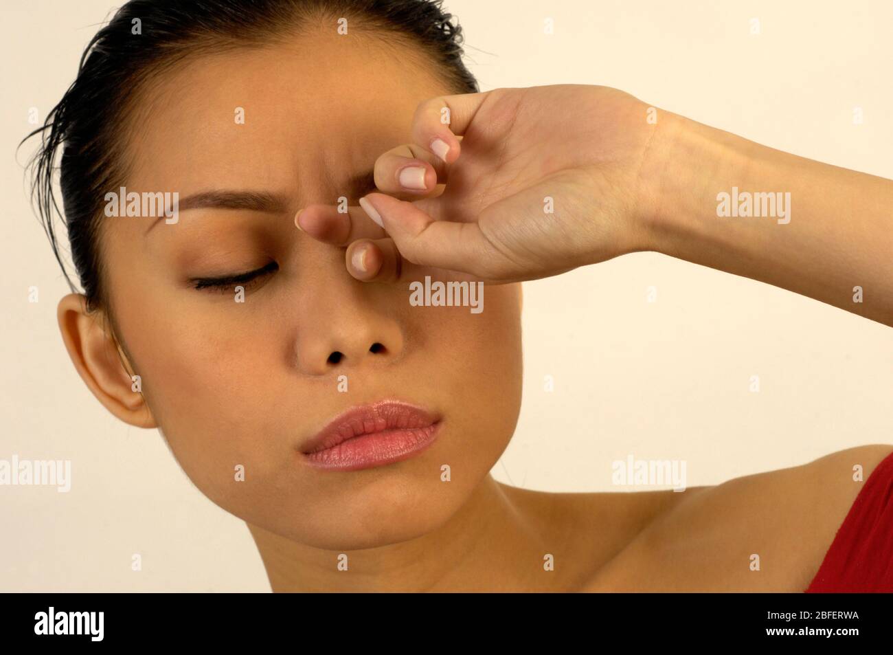 A young distressed woman holding her left hand over her left eye Stock ...