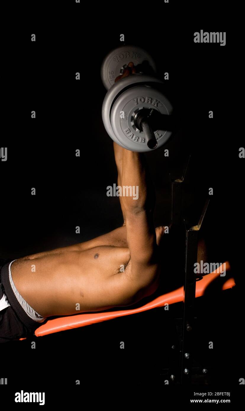 Man performing bench press exercise using hi-res stock photography and ...