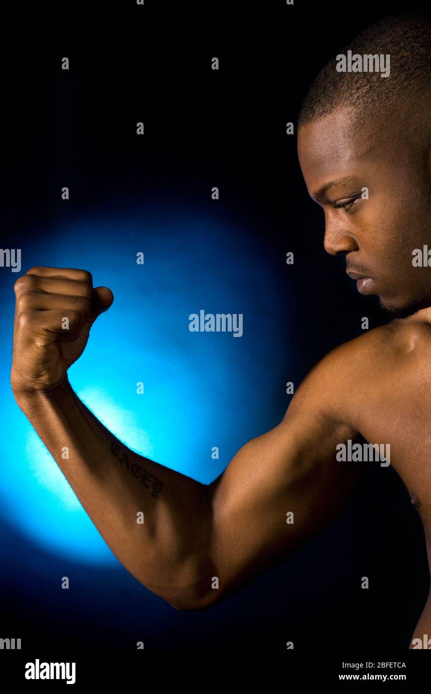 A young male tensing his right bicep muscle Stock Photo - Alamy