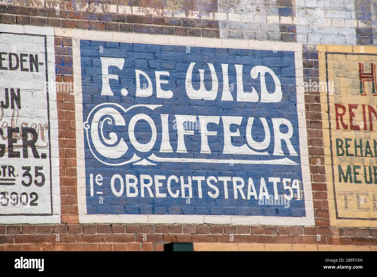 An old sign on the side of a brick building Stock Photo - Alamy