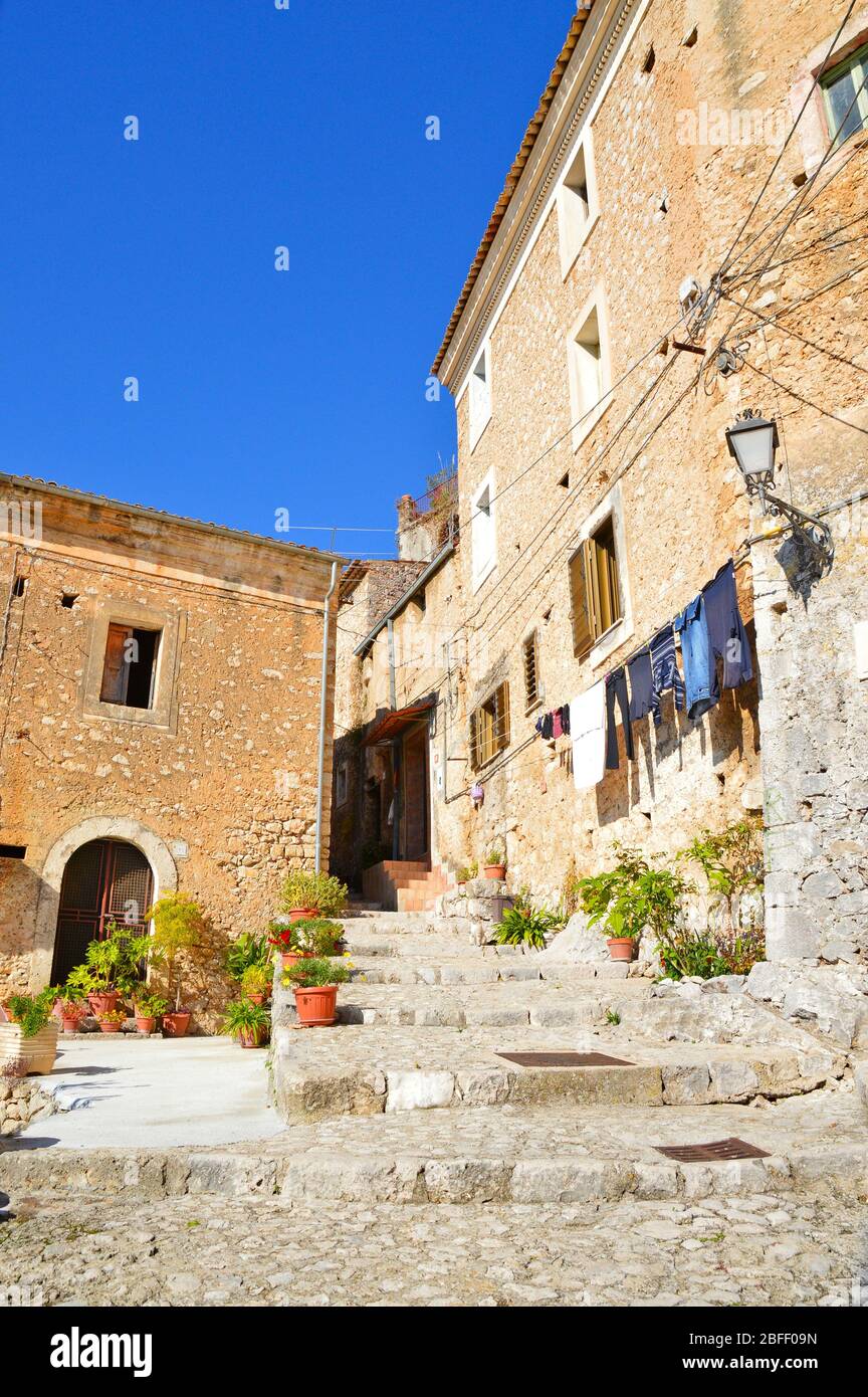 A narrow street between the old houses of the village of Caprile in the ...