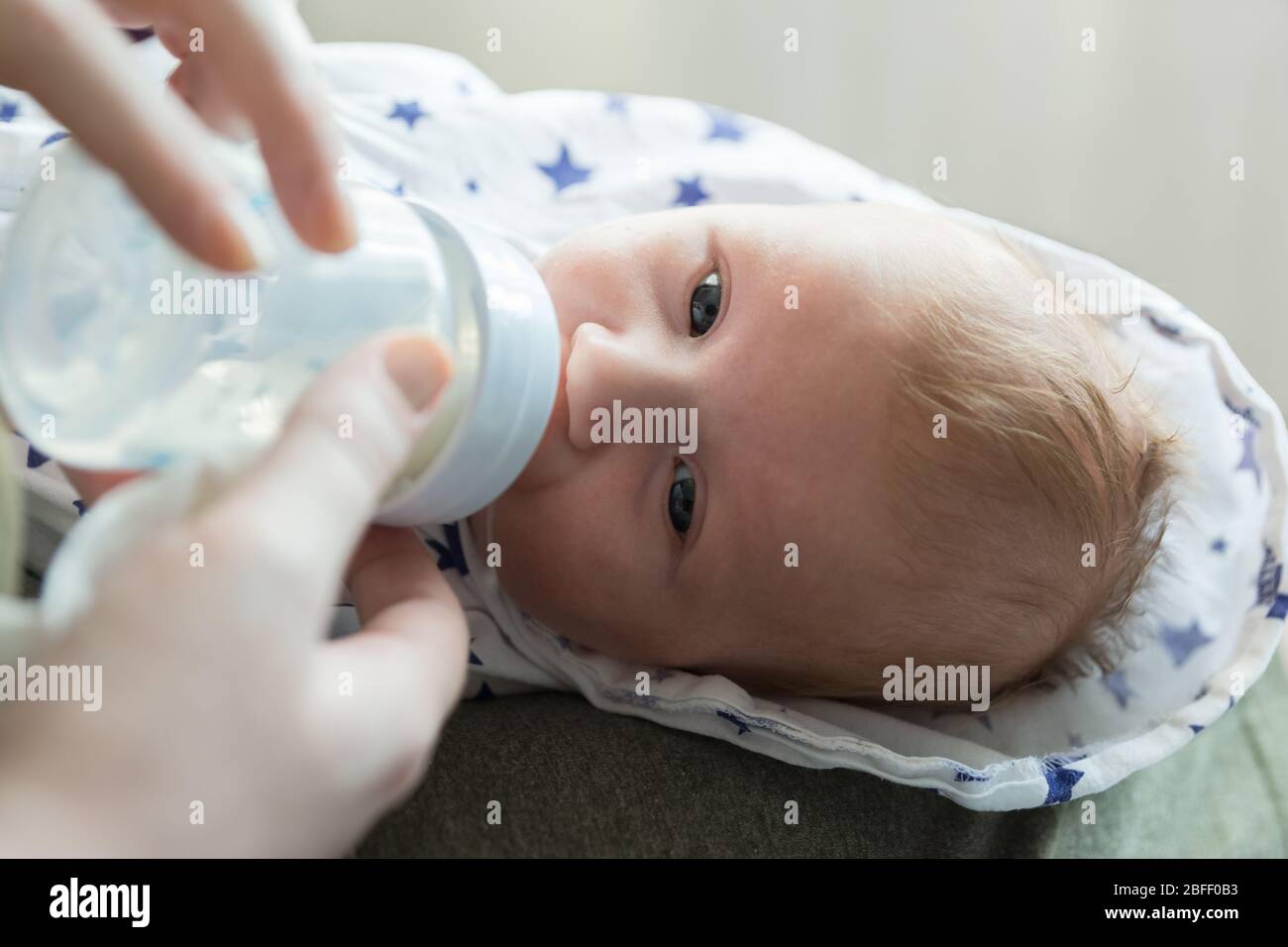 Feeding a small newborn baby formula from a bottle. Artificial feeding ...