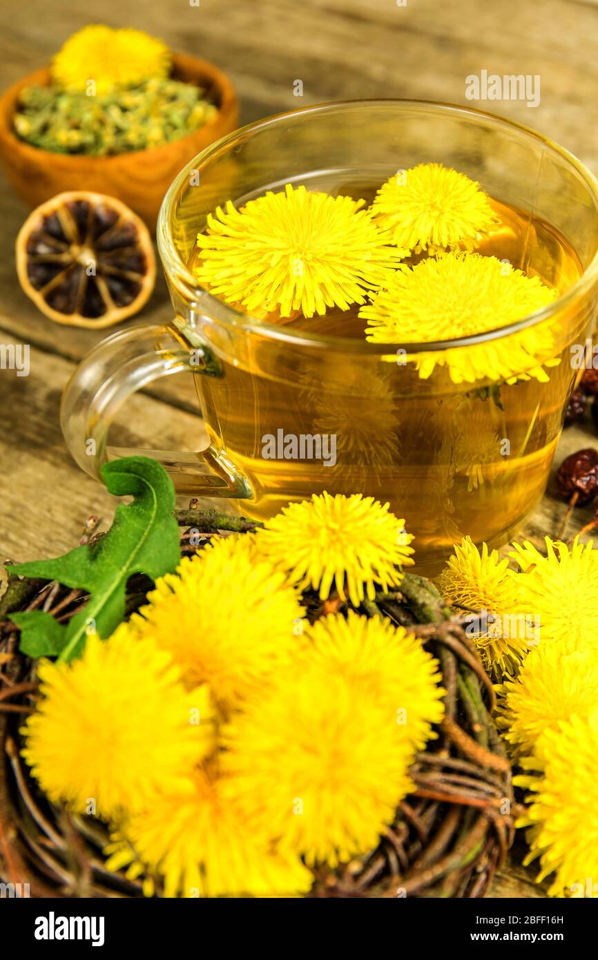 Herbal tea infusion of fresh dandelion leaf, with yellow blossoms ...