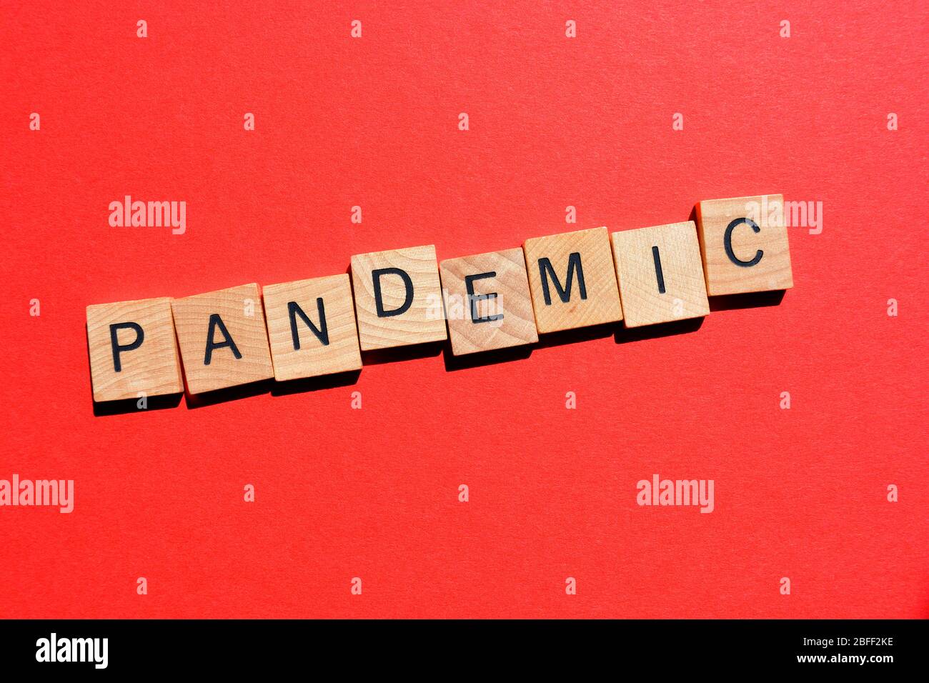 Pandemic, word in 3d wooden alphabet letters on bright red background ...