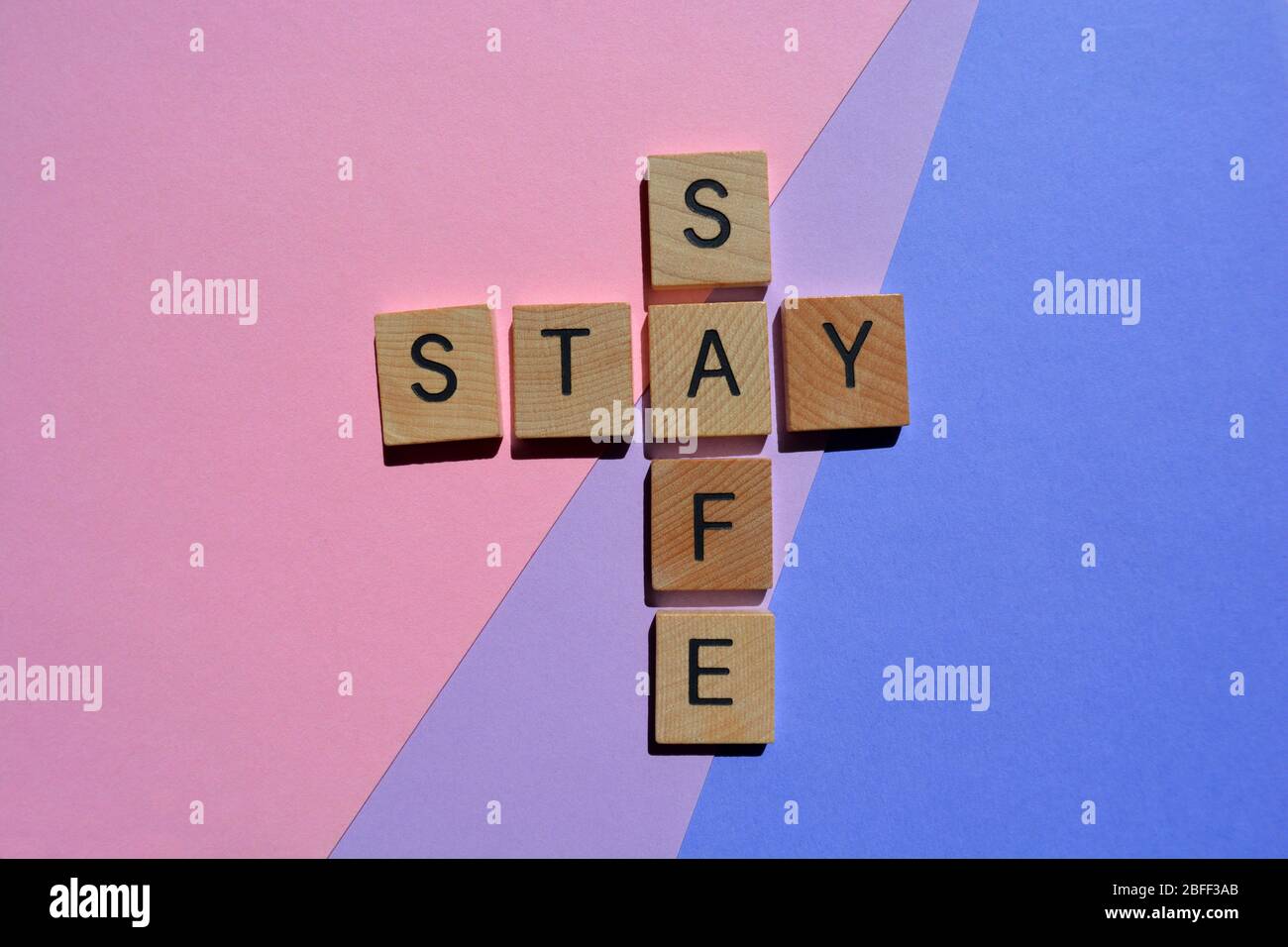 Stay Safe, words in 3d wood alphabet letters in a crossword on pastel ...