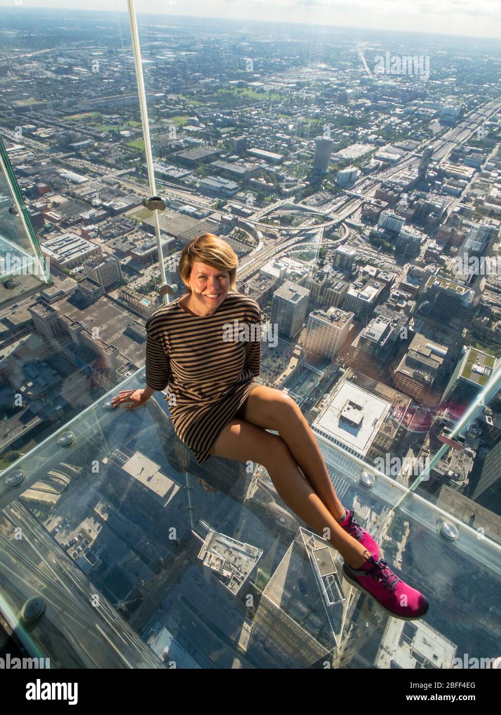 Tourists posing on a glass floor Stock Photo - Alamy